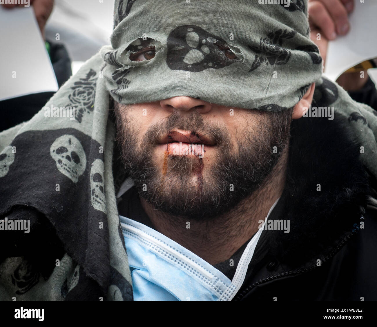 A group of Iranian asylum seekers stitch up their mouths to signify ...