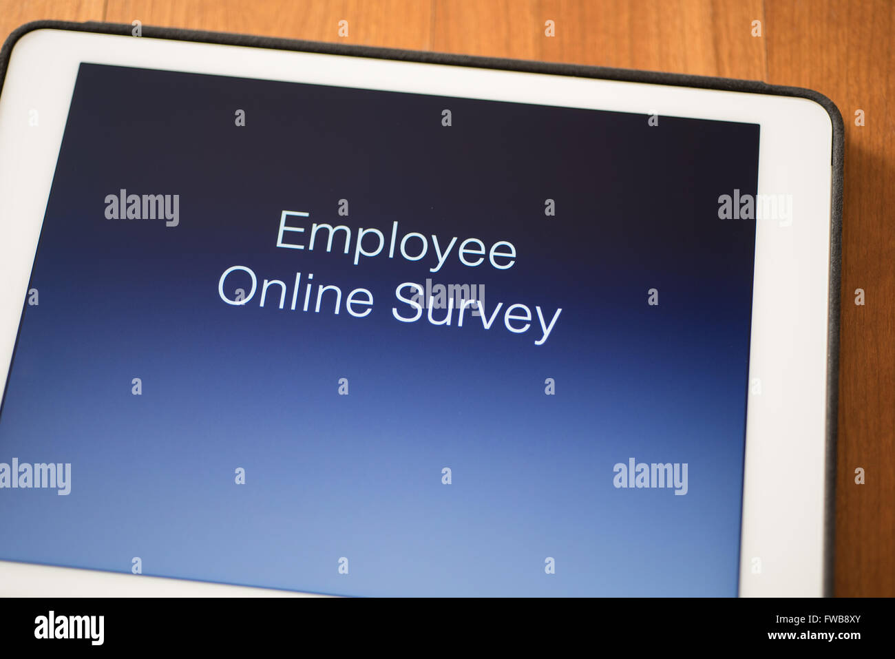 tablet on table with online employee survey Stock Photo - Alamy