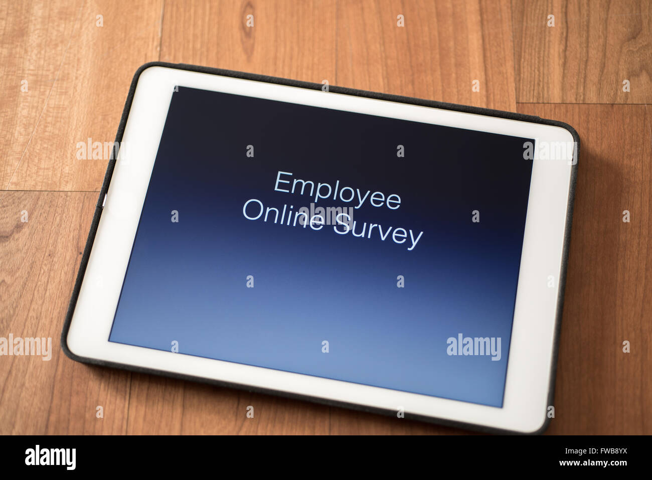 tablet on table with online employee survey Stock Photo - Alamy