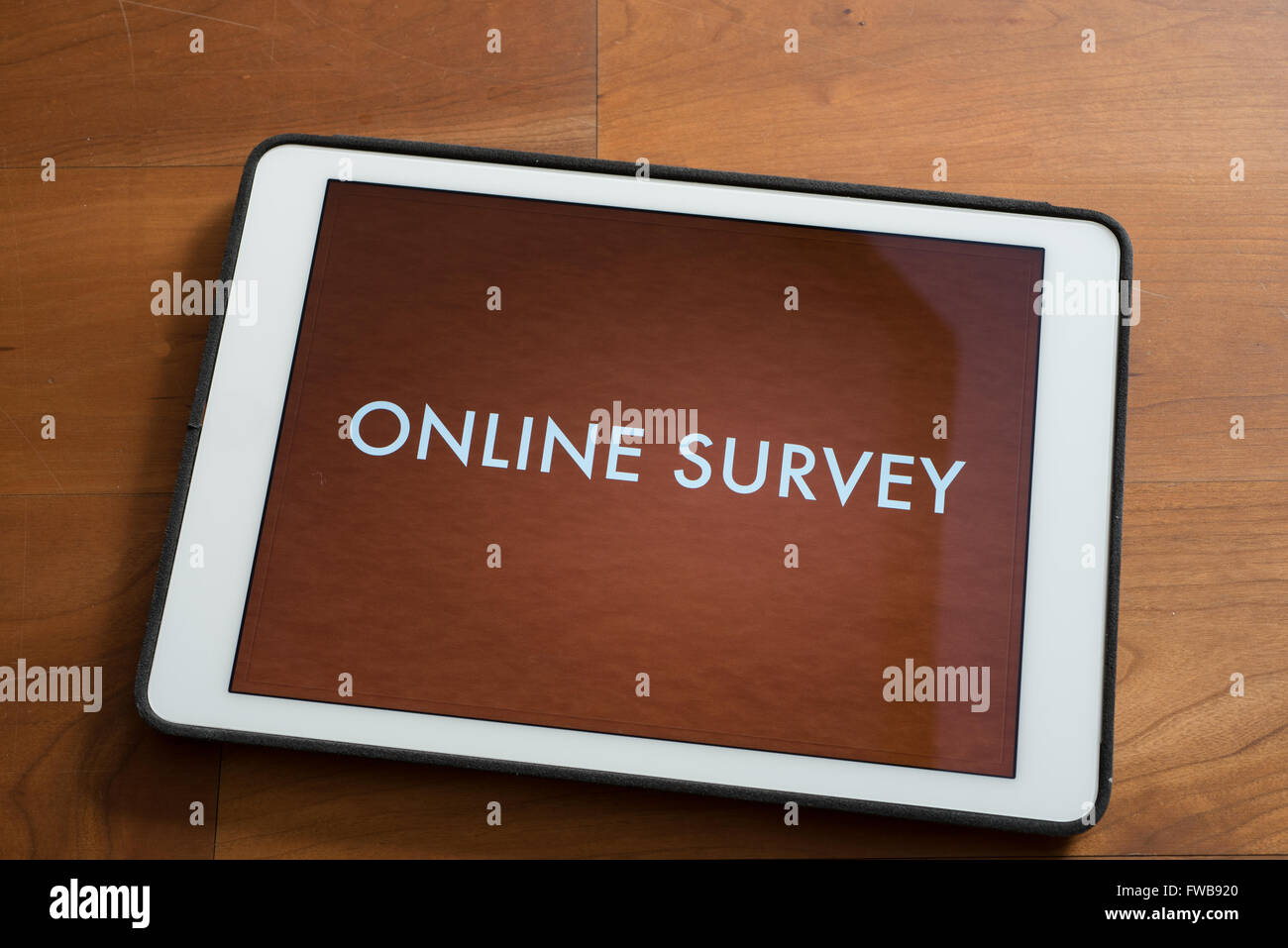 tablet on table with online customer survey Stock Photo - Alamy