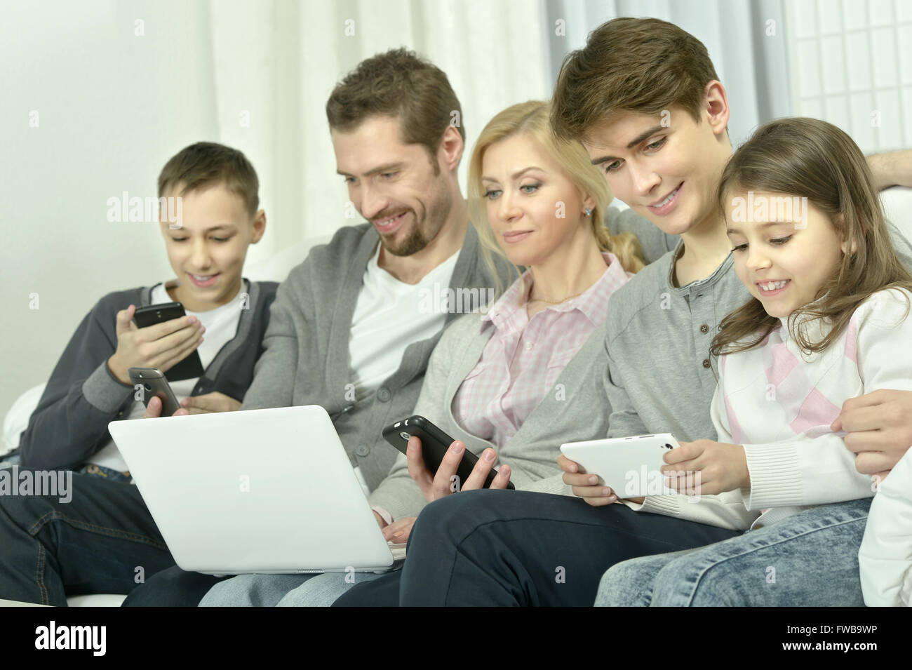 happy family with electronic gadgets Stock Photo - Alamy