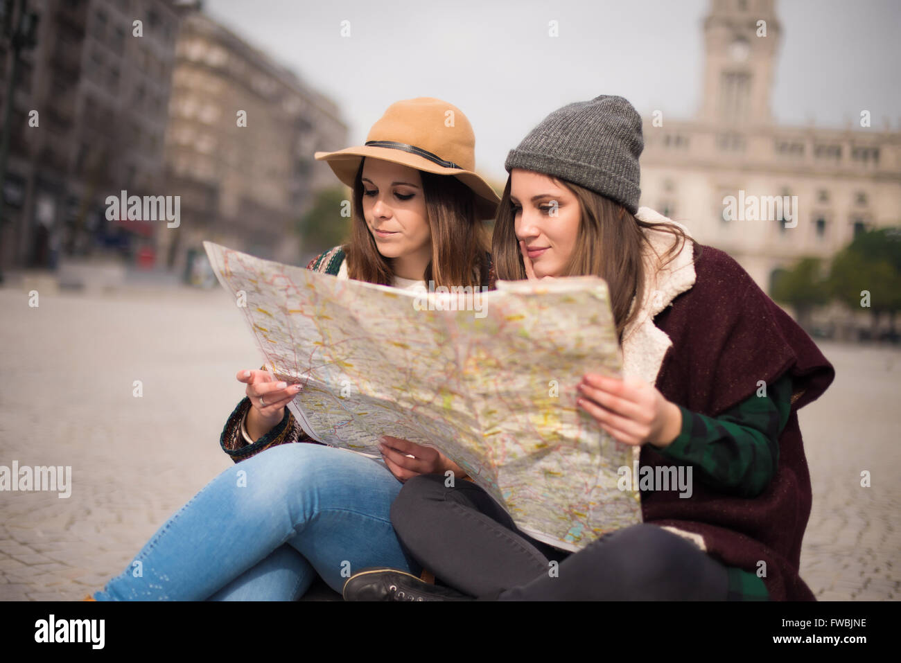 Female friends consulting a city map in the winter Stock Photo - Alamy
