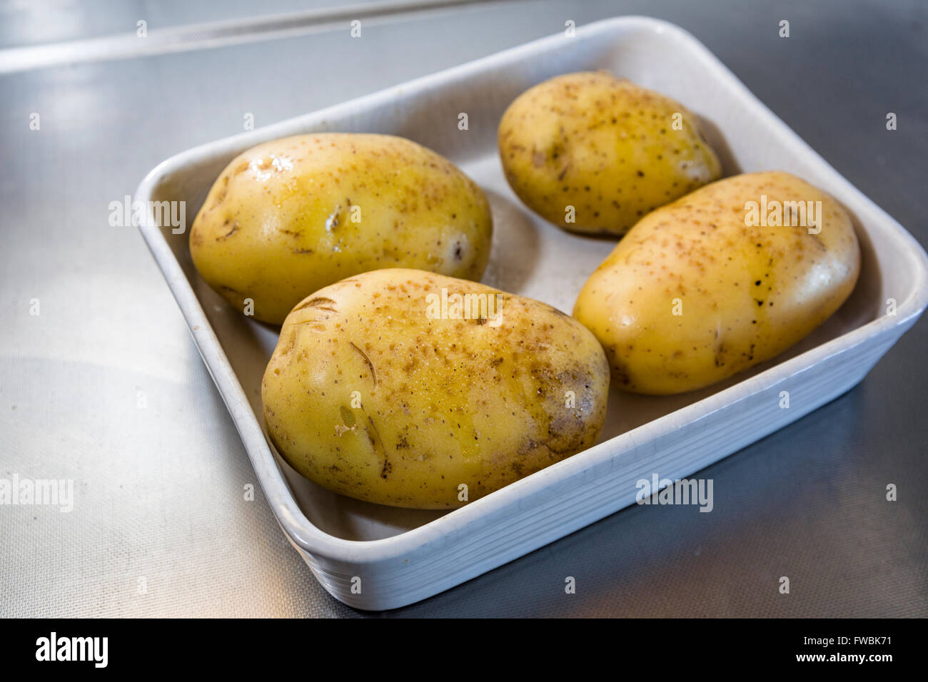 Large prepared potatoes ready to be put in oven to be baked potatoes ...