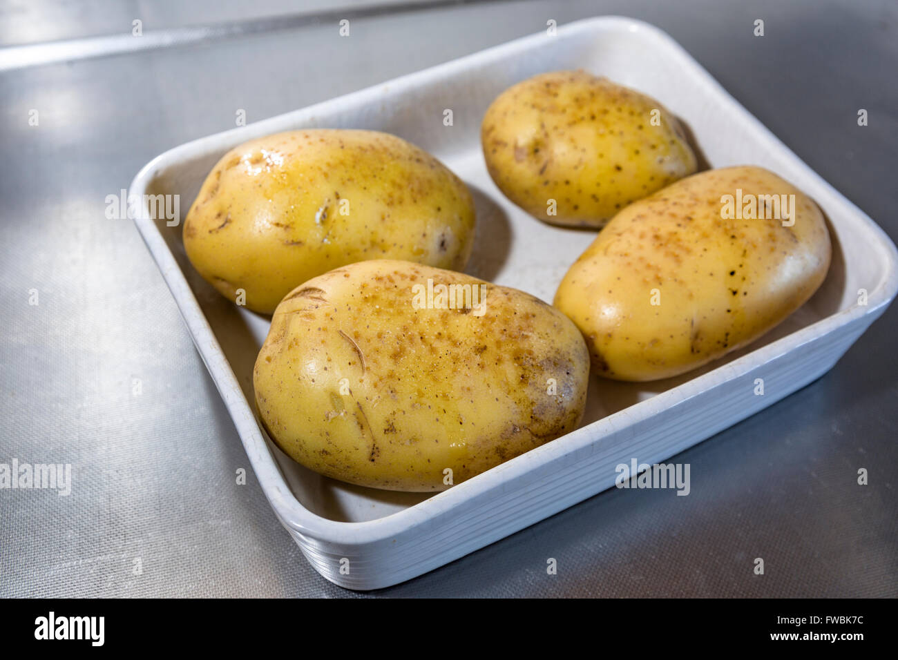 Large prepared potatoes ready to be put in oven to be baked potatoes ...