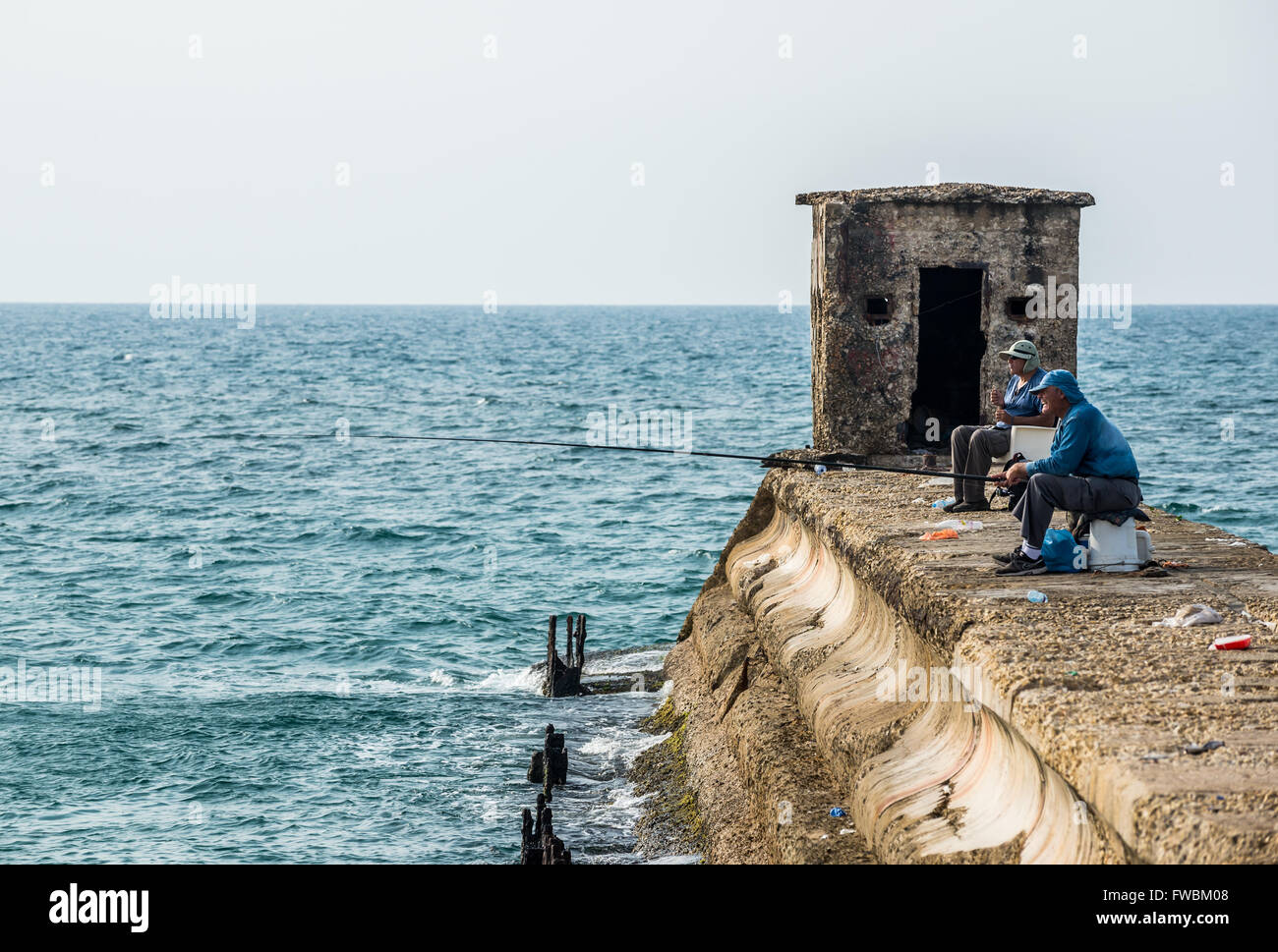 Men fishing on a breakwater in Tel Aviv Port neighbourhood, Tel Aviv ...