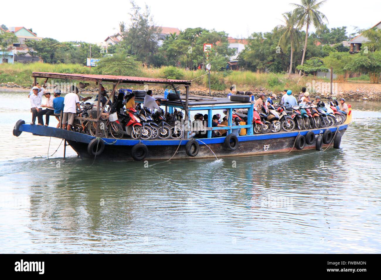 Ferry boat overloaded with motorbikes crossing river, Hoi An, Vietnam ...