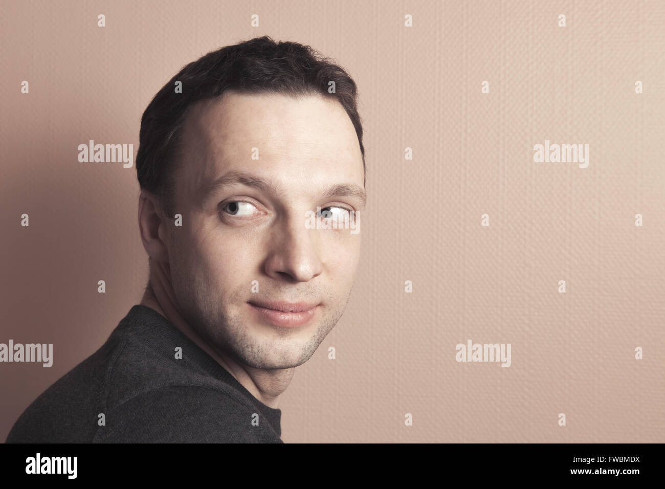 Young positive Caucasian man portrait over gray wall background ...