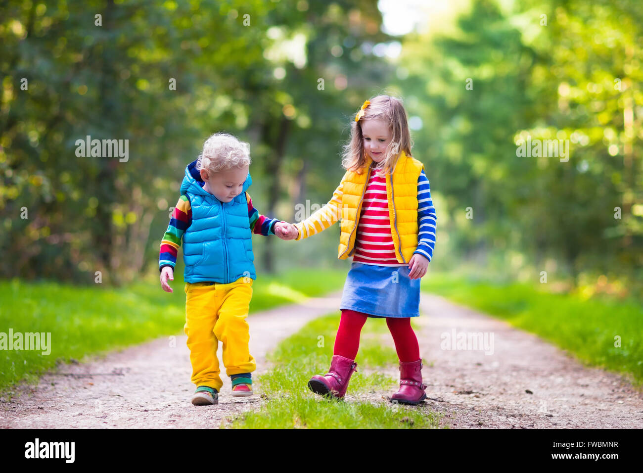 A boy and a girl playing in the autumn forest hi-res stock photography ...