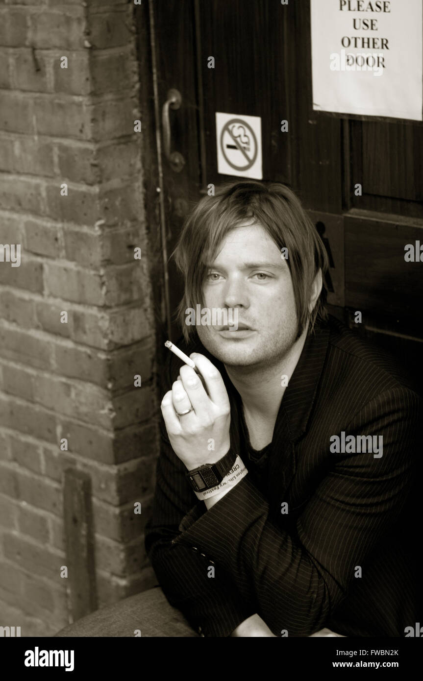 Portrait of writer Stuart Evers smoking a cigarette. Stuart's books ...