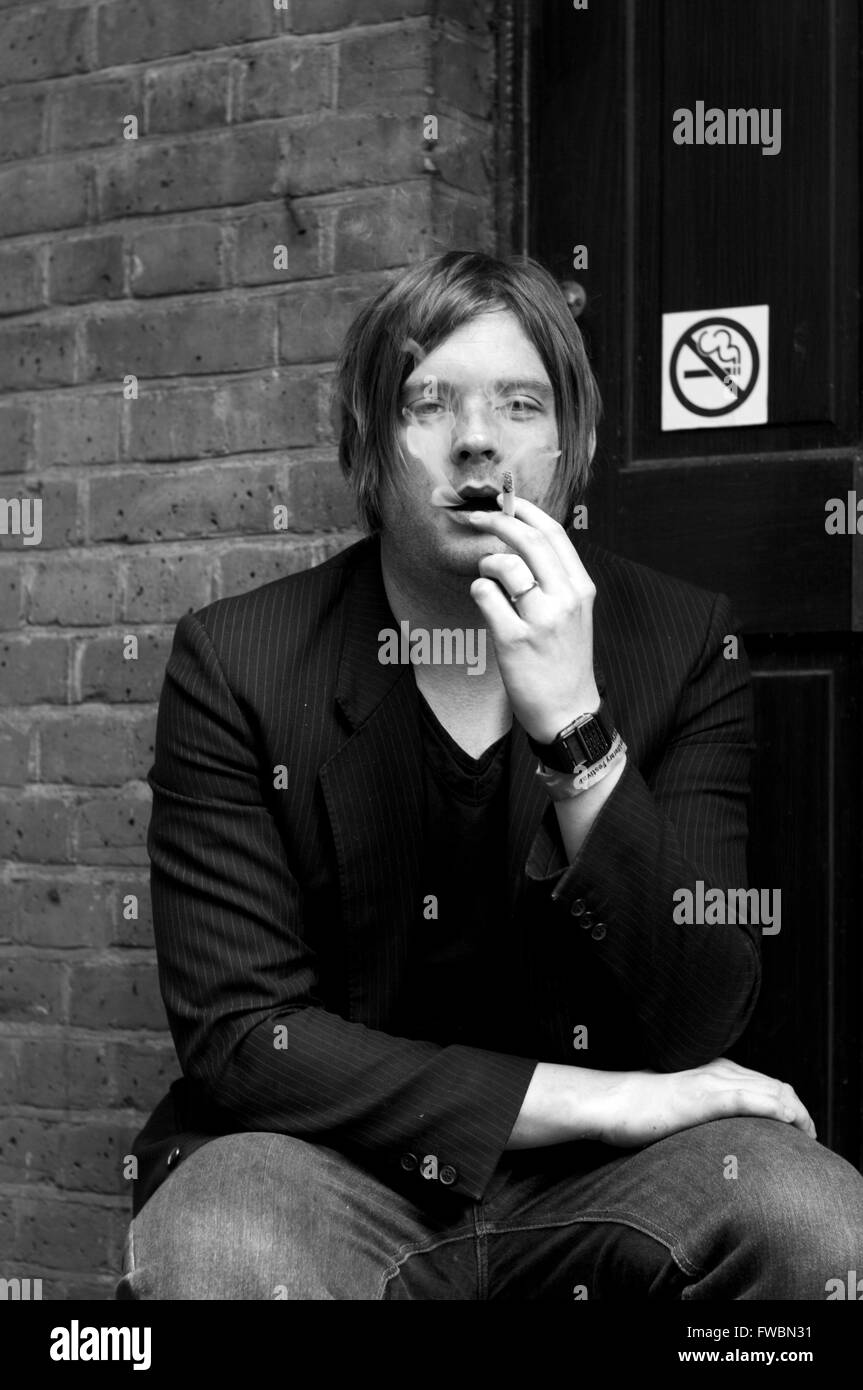 Portrait of writer Stuart Evers smoking a cigarette. Stuart's books ...