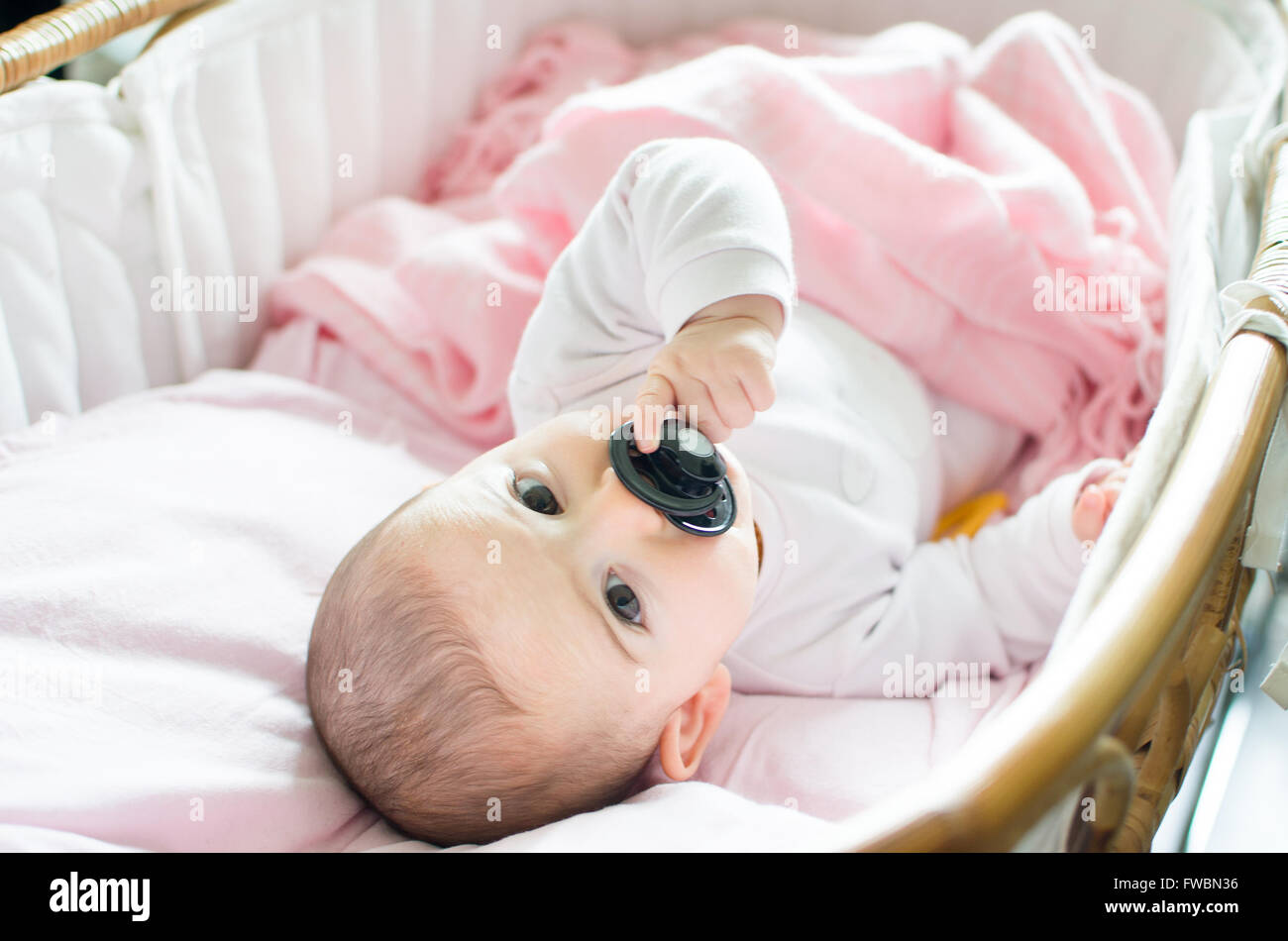 newborn pink cradle hold black pacifier hand Stock Photo - Alamy