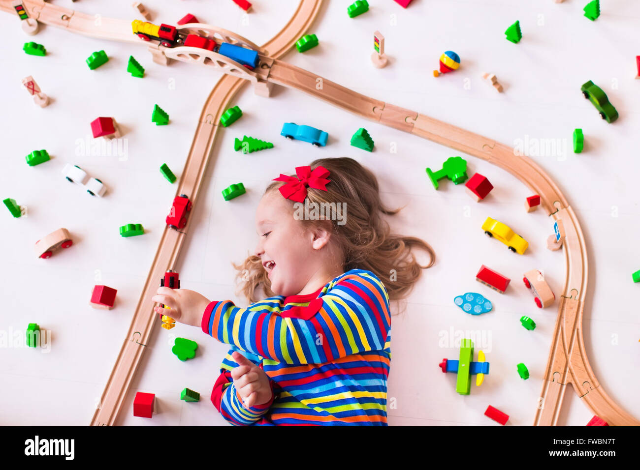 Child playing with wooden train, rails and cars. Toy railroad for kids ...