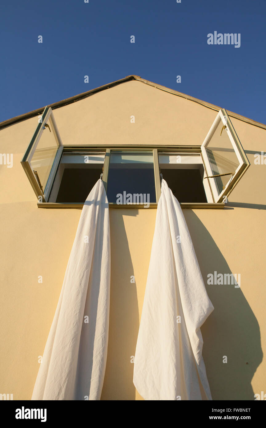 Two sheets hung from the upper floor windows of a house in the sunshine ...