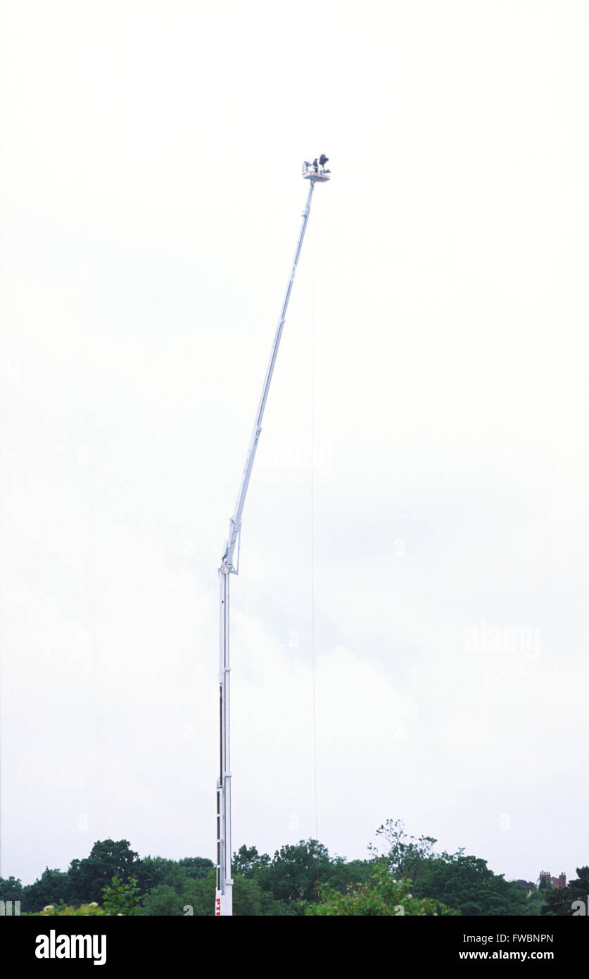 An outside broadcast cameraman is elevated above the treetops on the ...