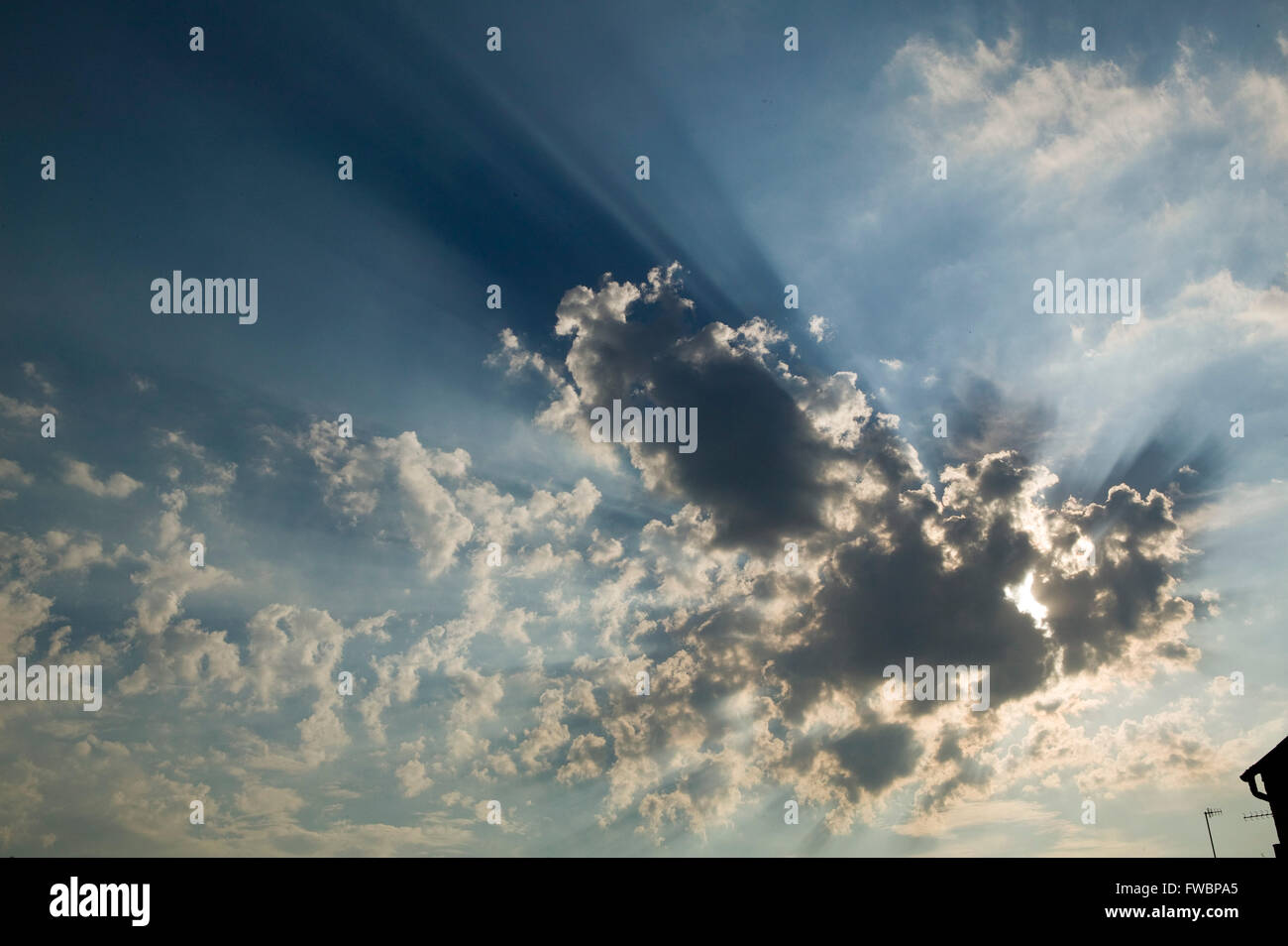 Large clouds block out the sun sending huge rays of light spilling out ...