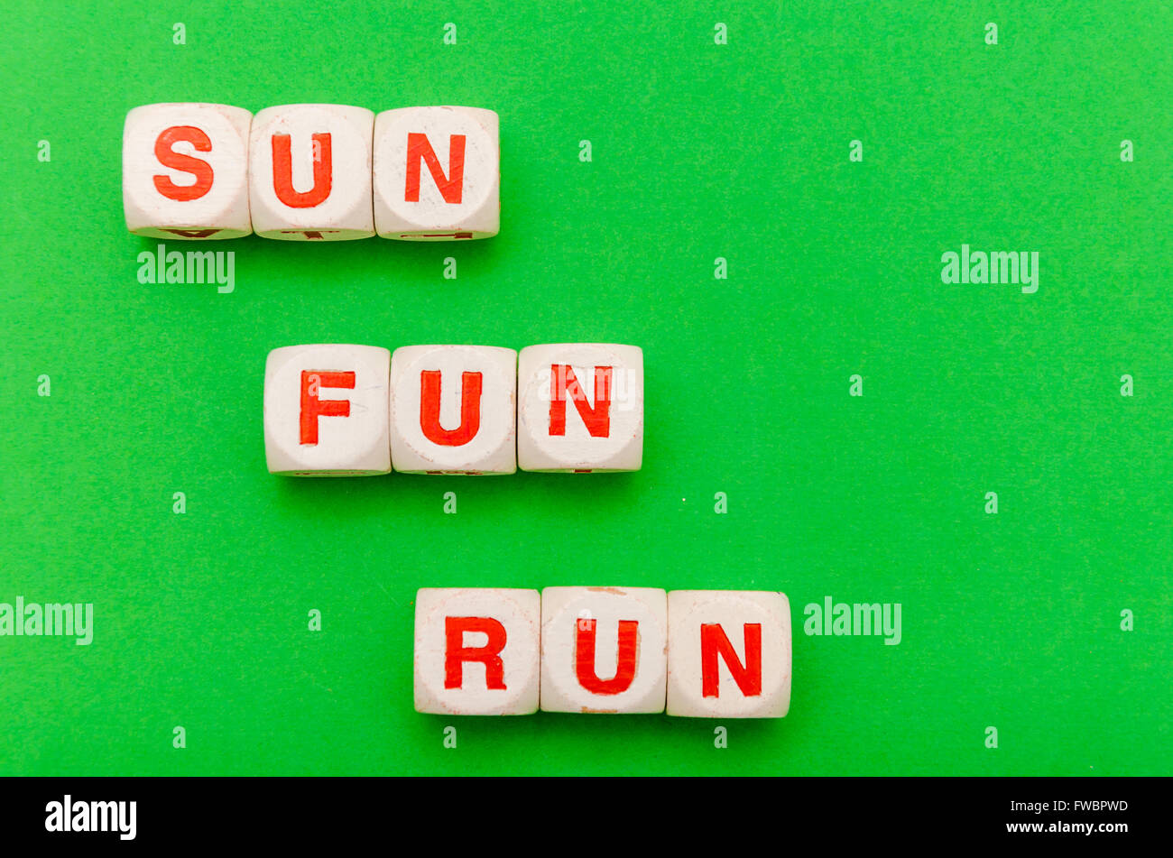 still life with dices and the word sun fun and run, green background ...