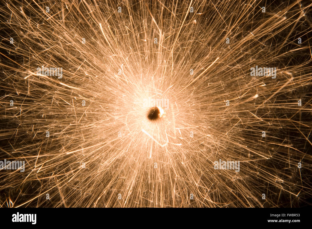 Sparks from a sparkler radiate outwards from the central core of the ...