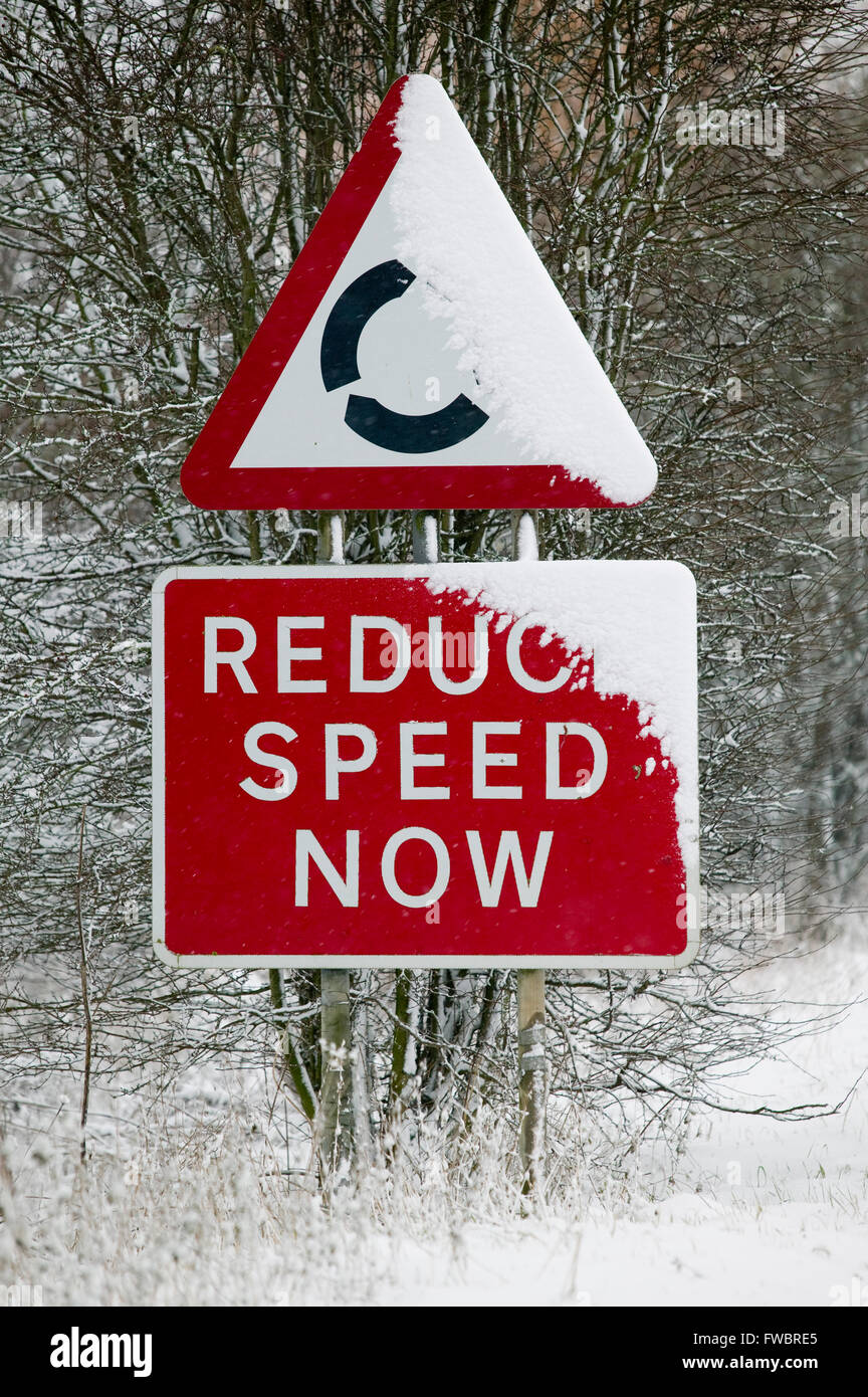 A road traffic sign covered in snow warning of an up and coming ...