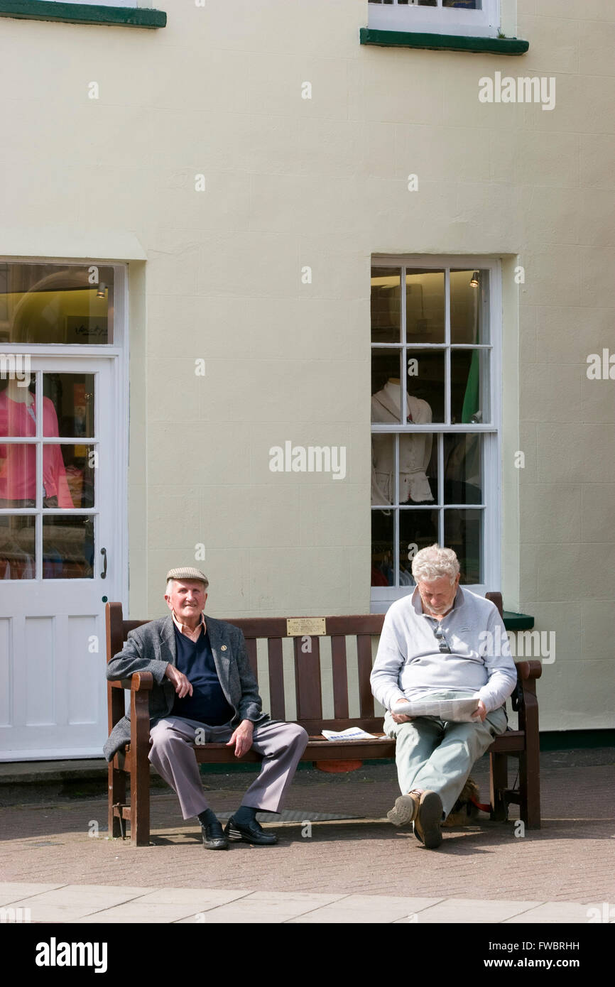 A couple of old local men sitting on a bench in the centre of town and ...