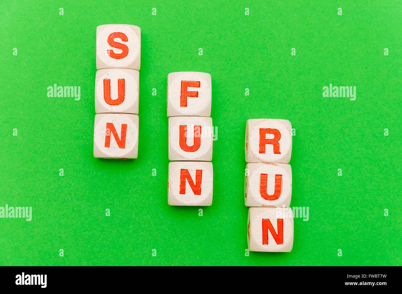 still life with dices and the word sun fun and run, green background ...