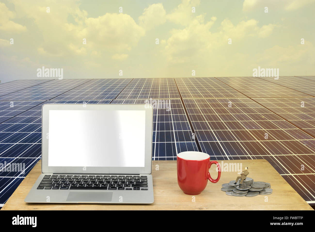 laptop, red mug and miniature figure on wood table with solar panel ...