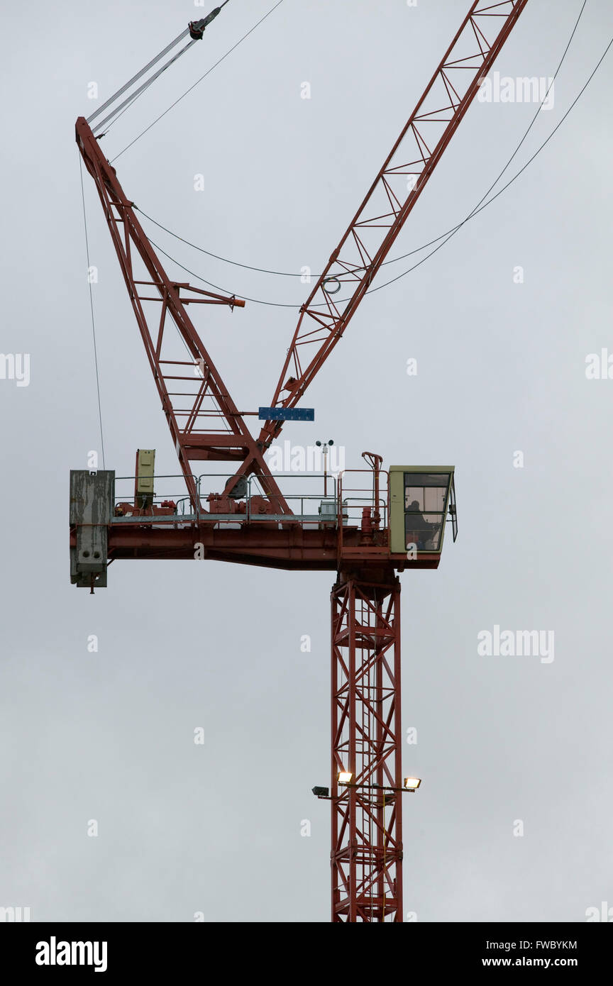 The top of a tall crane showing the cab and lifting arm on a ...