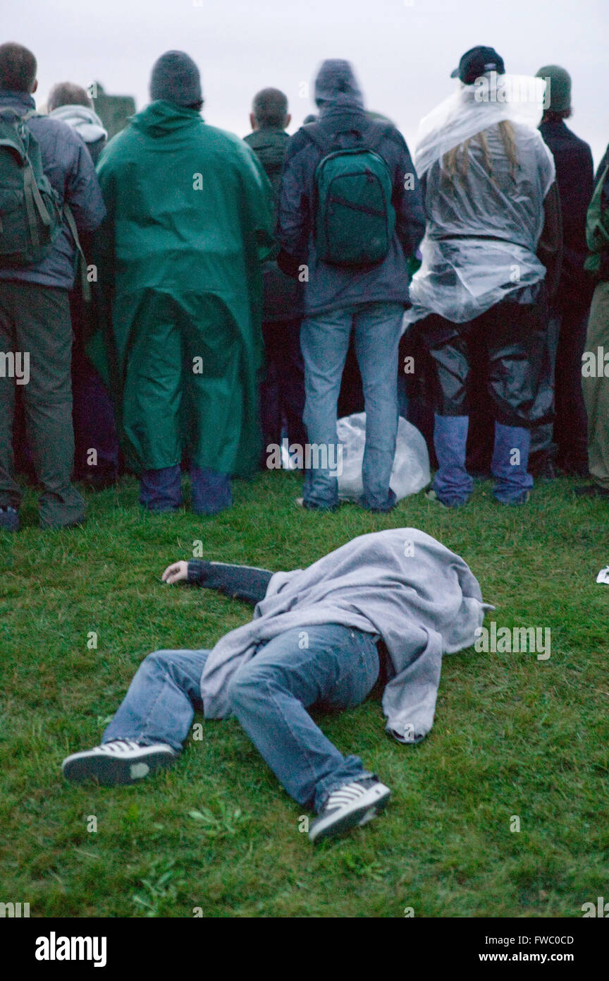 A young man fast asleep or passed out at an open air festival misses ...