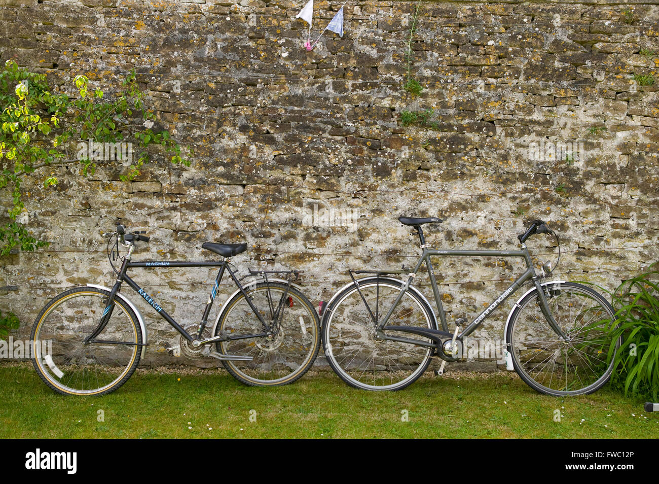 Two old bikes leanign against a tall wall Stock Photo - Alamy
