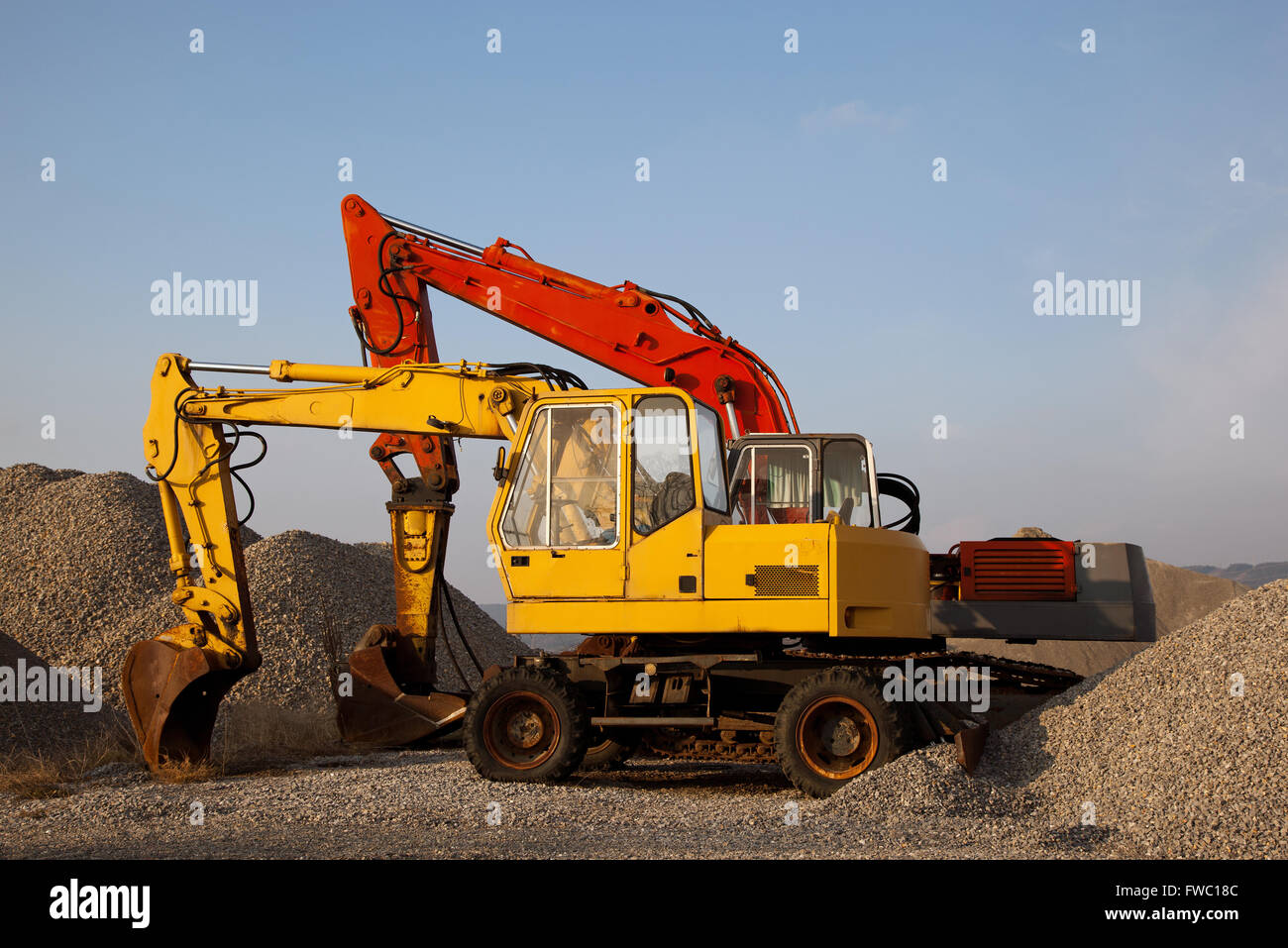Red and yellow excavator machine on a construction site Stock Photo - Alamy