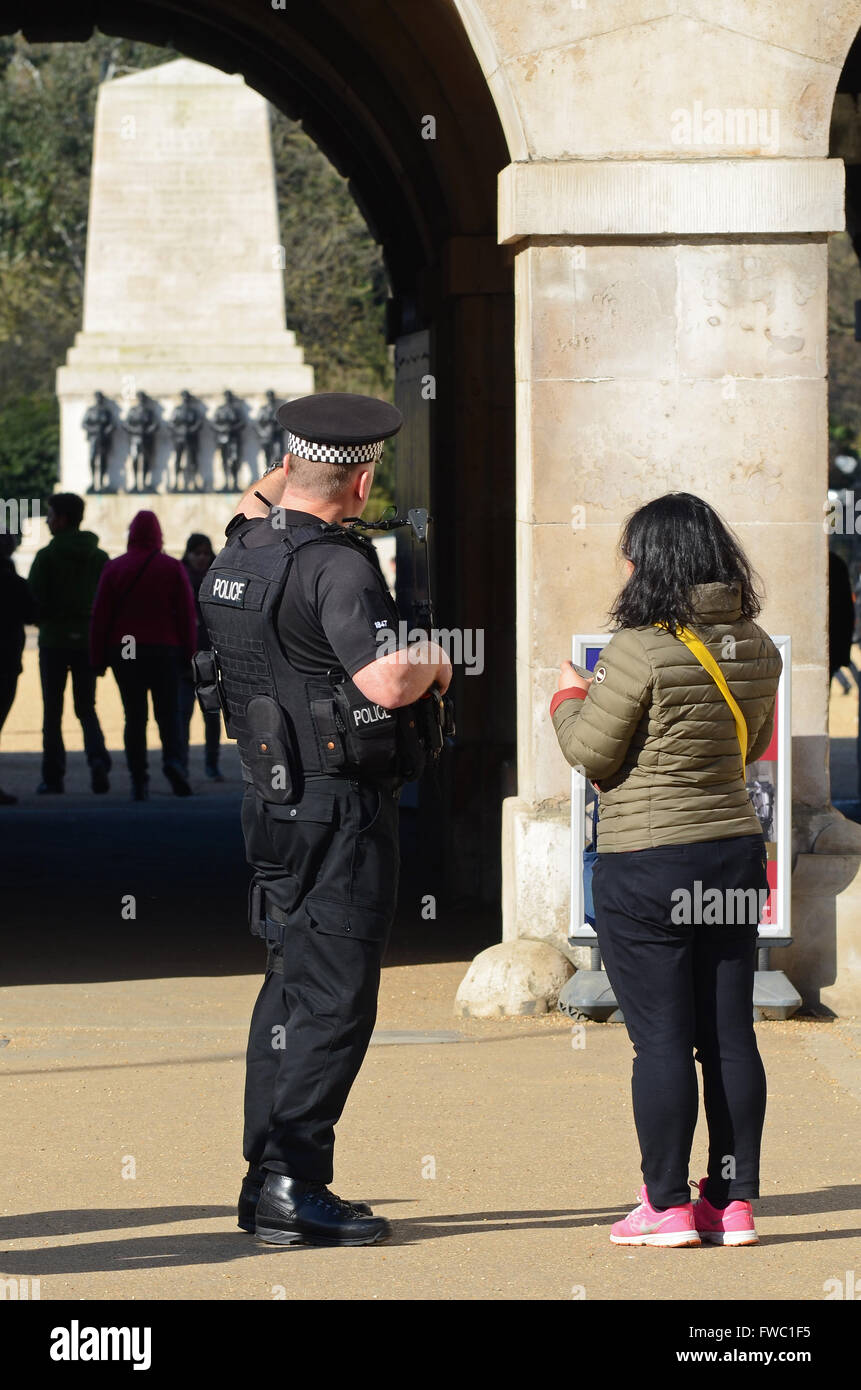 Armed policeman in London with lone female tourist outside of Horse ...