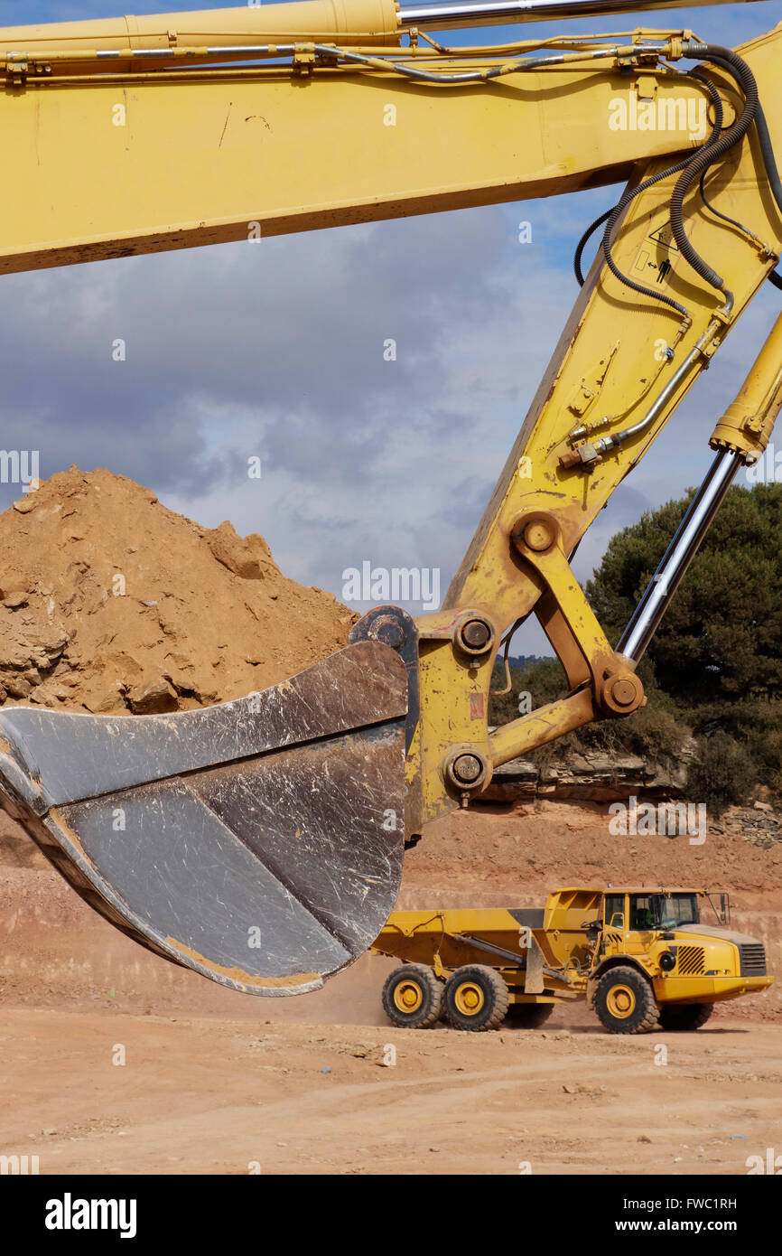 Heavy excavator and truck, working in a large excavation Stock Photo ...