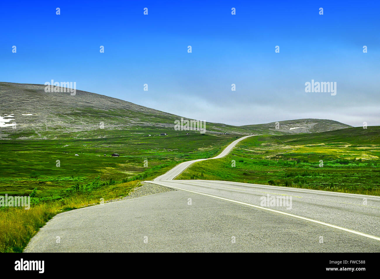 A long winding asphalt road without cars in the mountain valley and ...