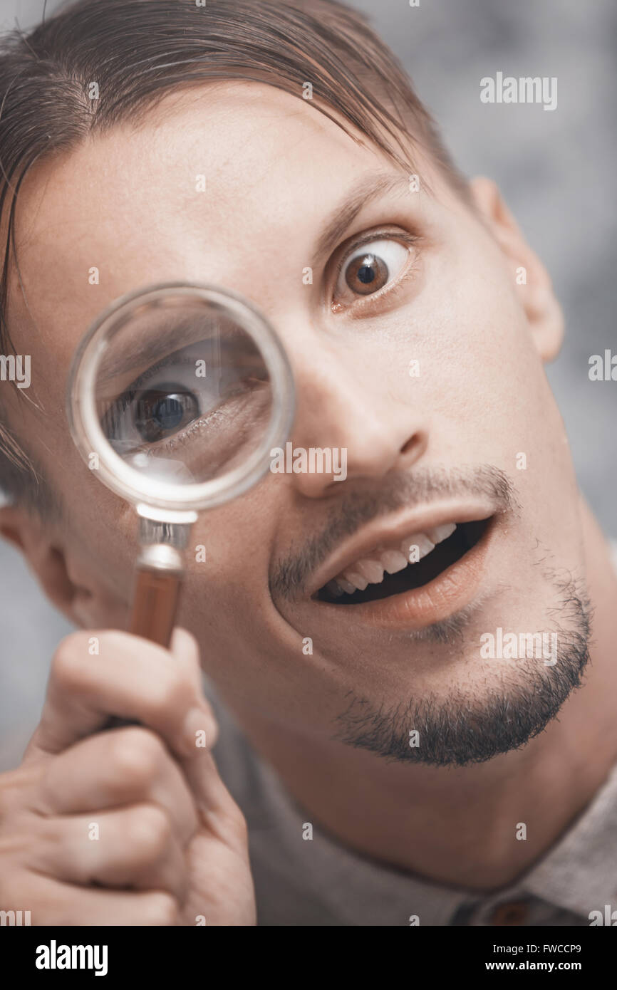 Man with magnifying glass. Vertical portrait Stock Photo - Alamy