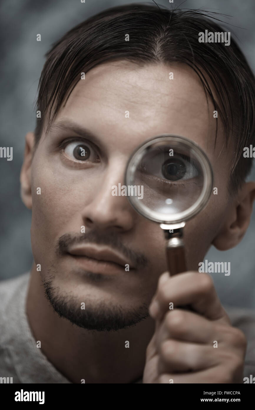 Man with magnifying glass. Vertical portrait Stock Photo - Alamy