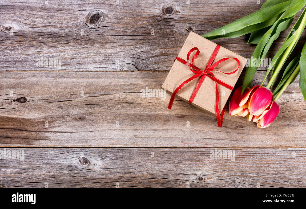 Tulips and present, upper right hand corner, on rustic wood. Overhead ...