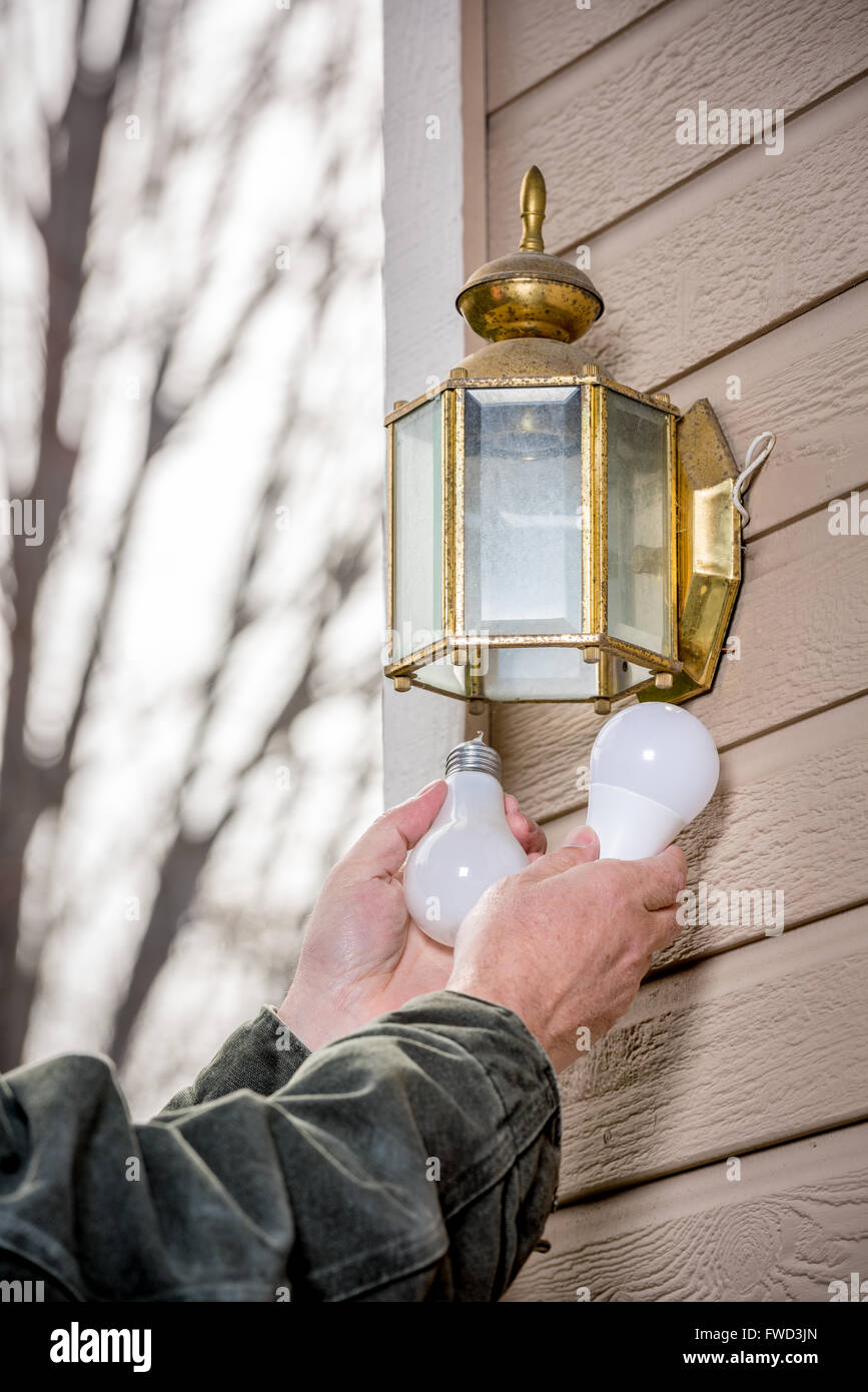 Old light bulb is replaced with an LED style light Stock Photo - Alamy
