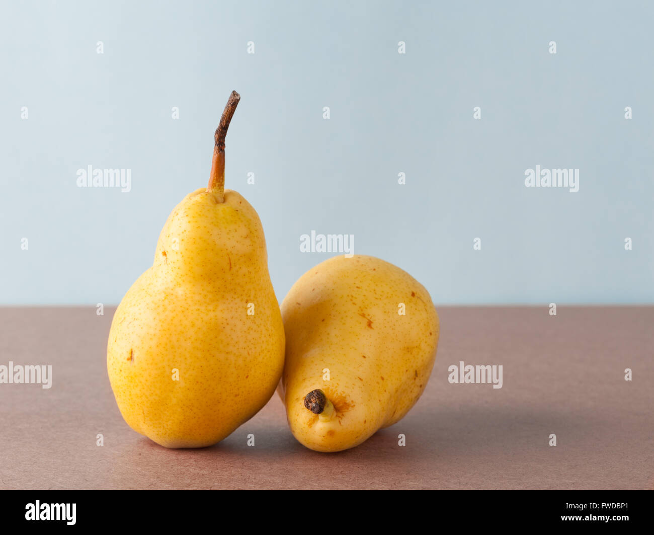 Two whole yellow Corella pears on wooden surface with copy space Stock ...
