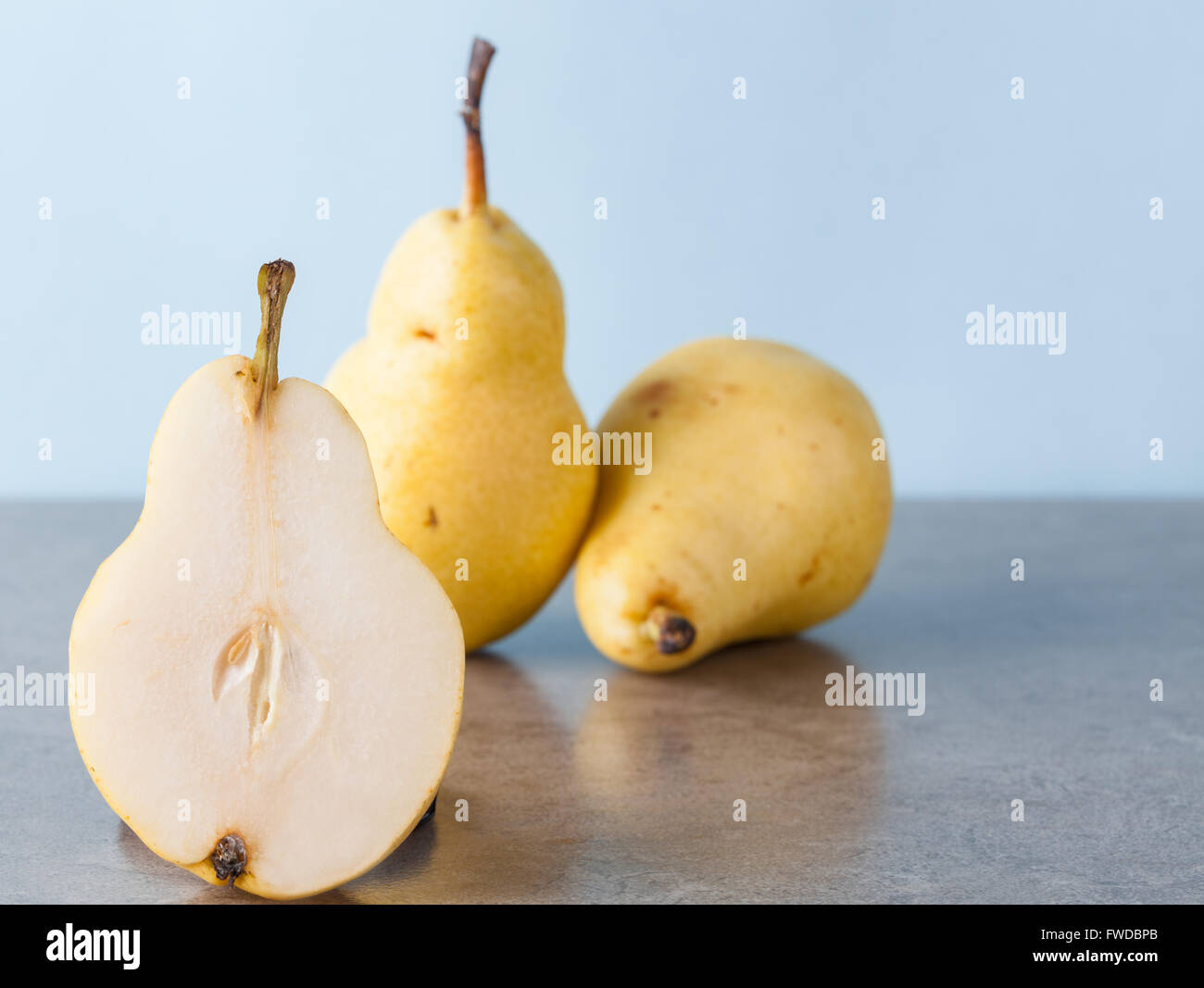 Whole and halved yellow Corella pears with copy space Stock Photo - Alamy