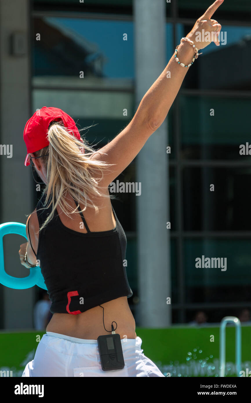 Blonde Female Instructor with Red Hat and Microphone Teaching Aqua ...