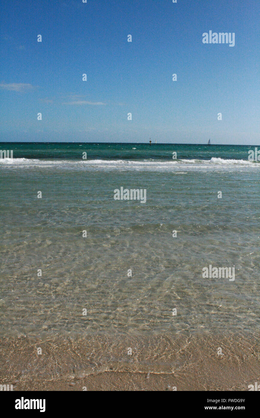 The sun hits the water as the waves roll in Stock Photo - Alamy