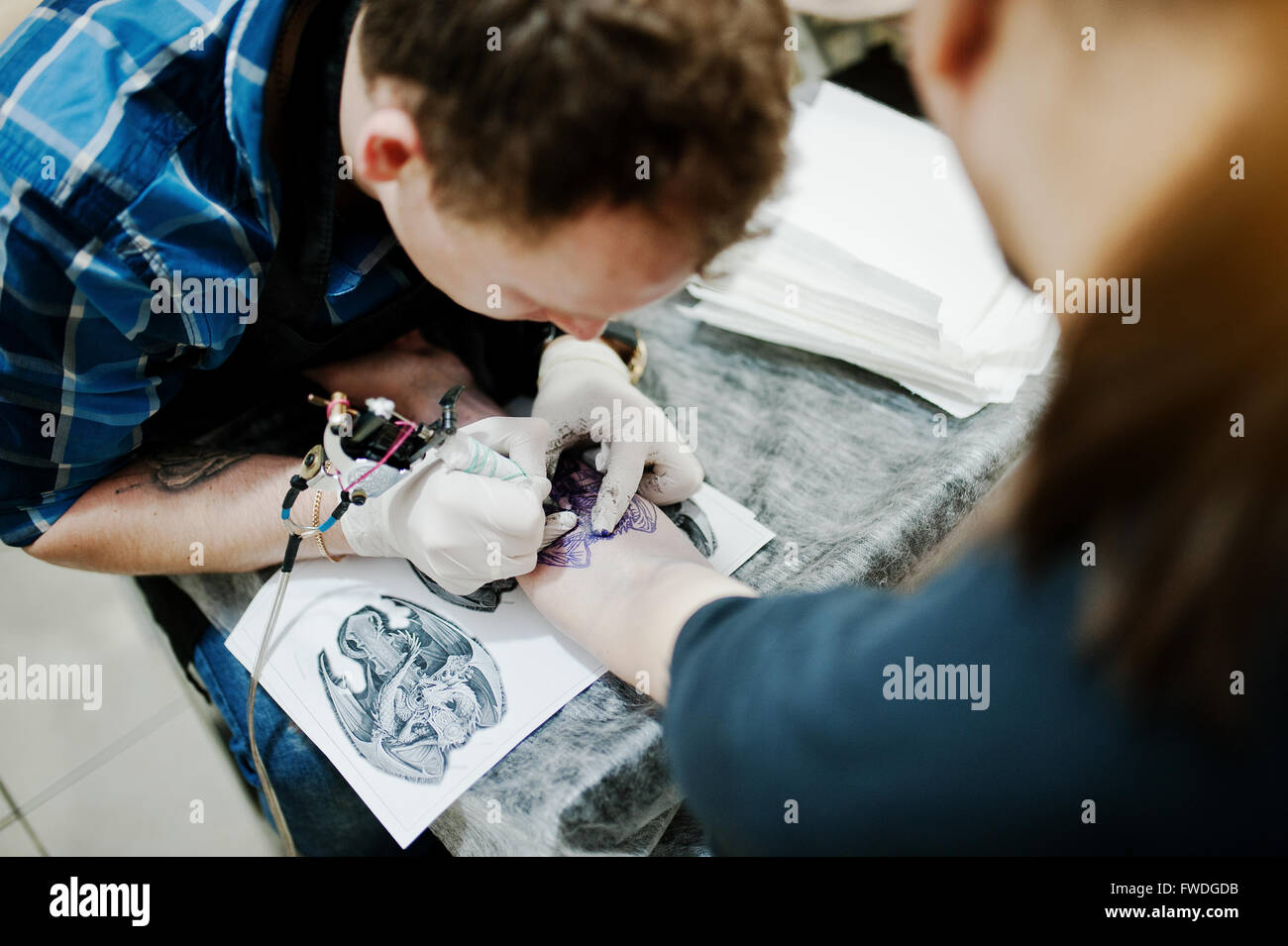 Tattoo master make tattoo for rocker man at tattoo salon Stock Photo ...
