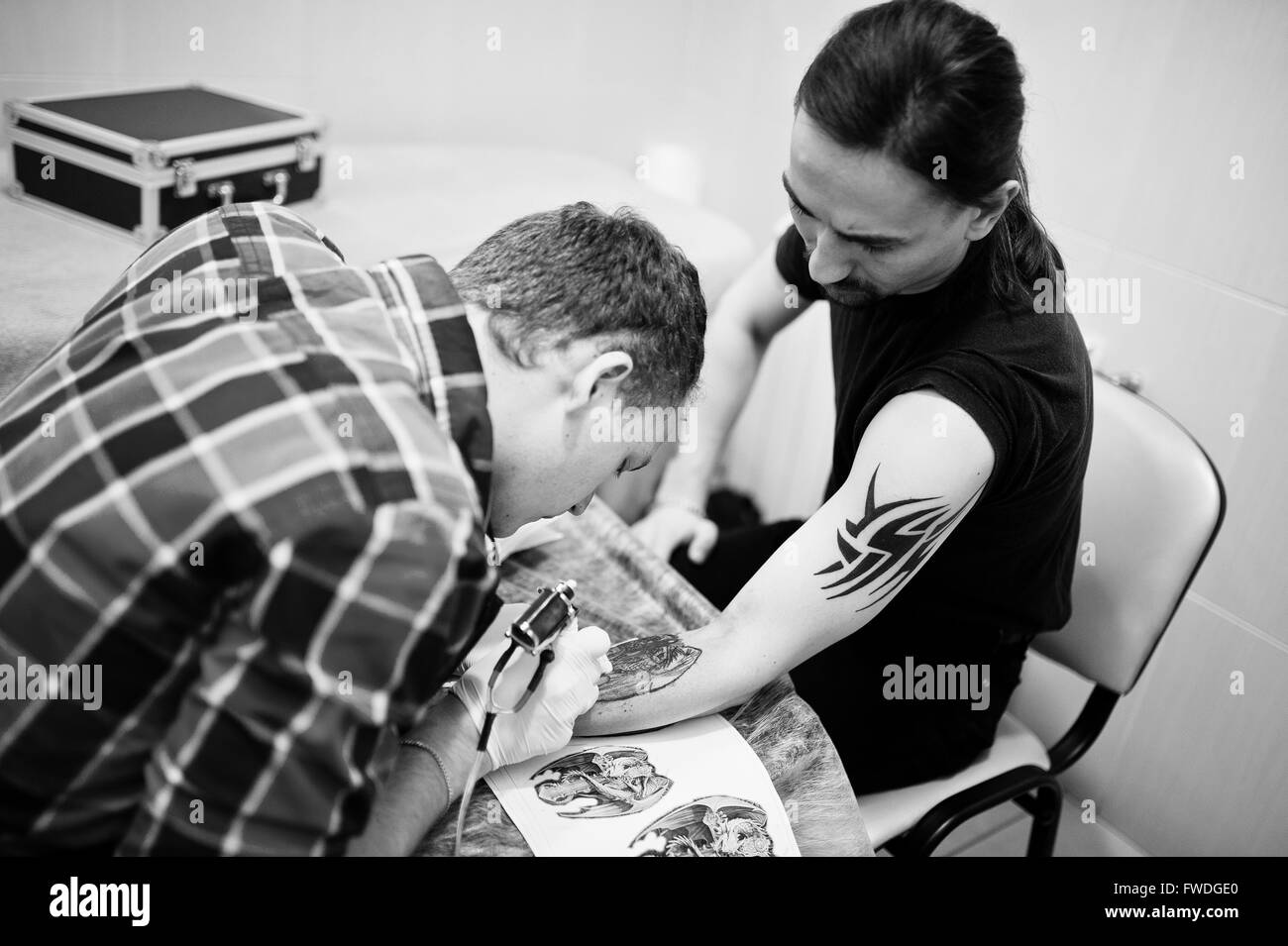 Tattoo master make tattoo for rocker man at tattoo salon Stock Photo ...