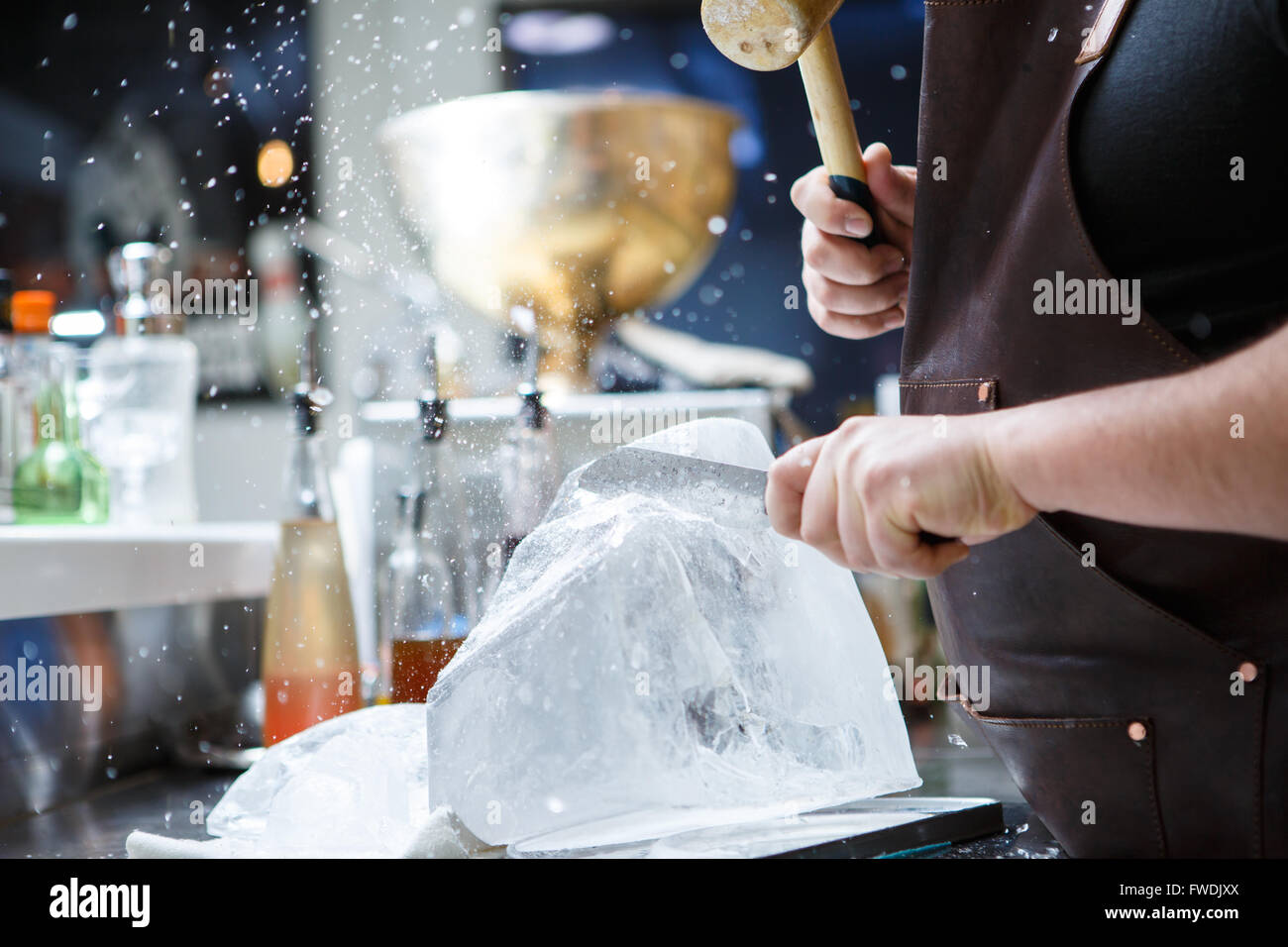 Bartender mannually crushed ice with wooden hammer and metal knife ...