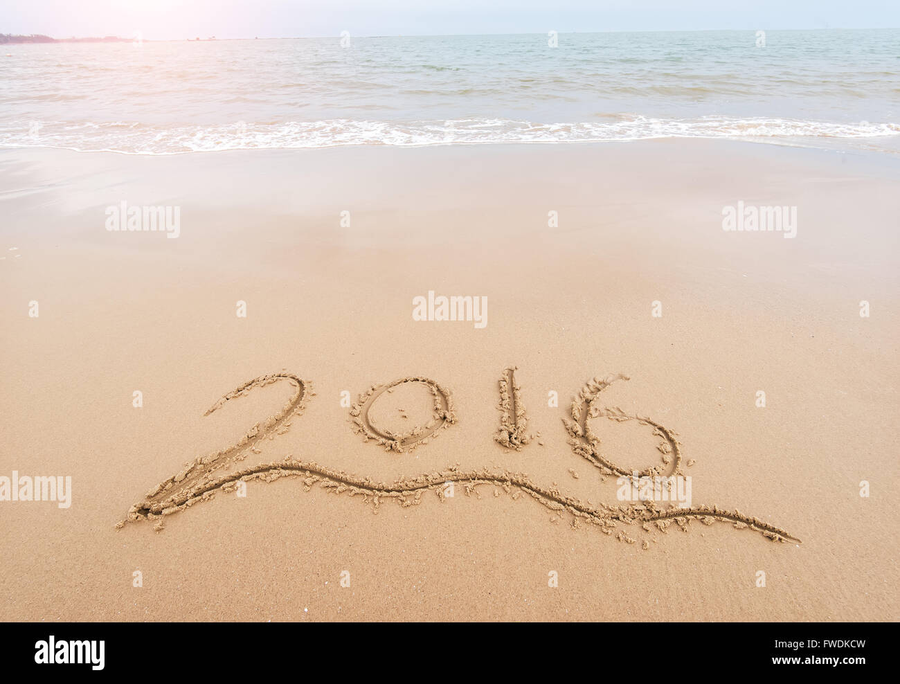 Year 2016 hand written on the white sand in front of the sea Stock ...