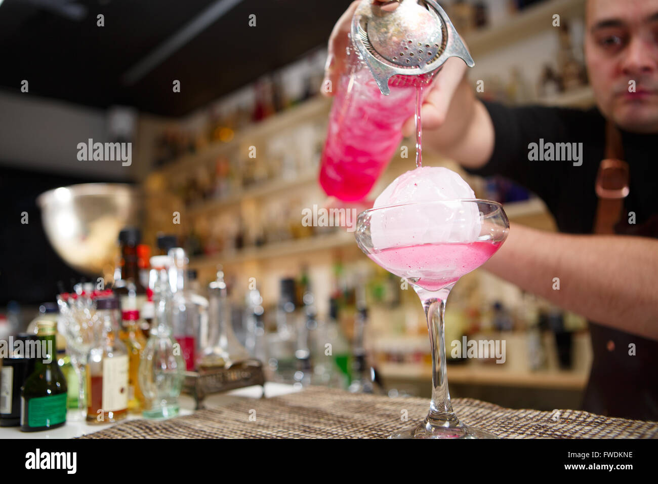 Close-up of bartender hand pouring pink cocktail drink in bar Stock Photo - Alamy