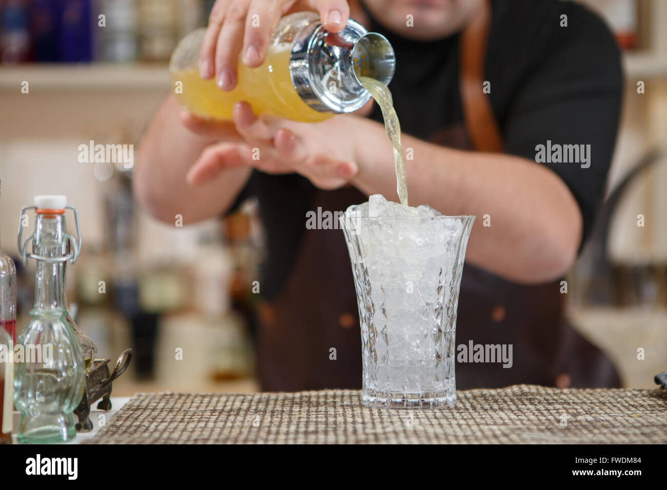 Bartender pouring cocktail into glass at the bar Stock Photo - Alamy