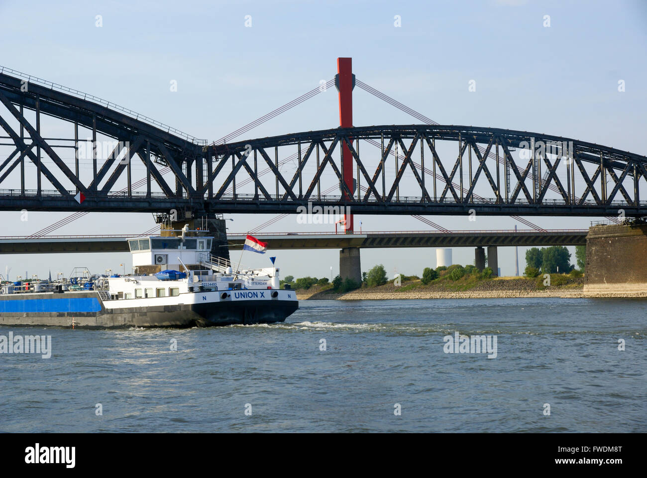 A barge passes under a bridge on the river Rhine near Arnhem, Nederland ...