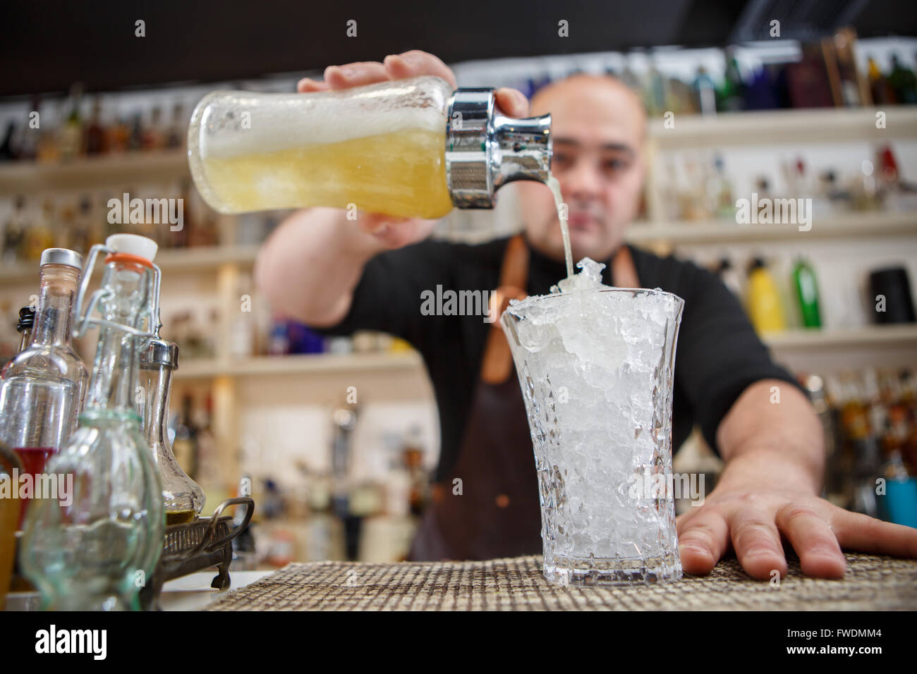 Bartender pouring cocktail into glass at the bar Stock Photo - Alamy