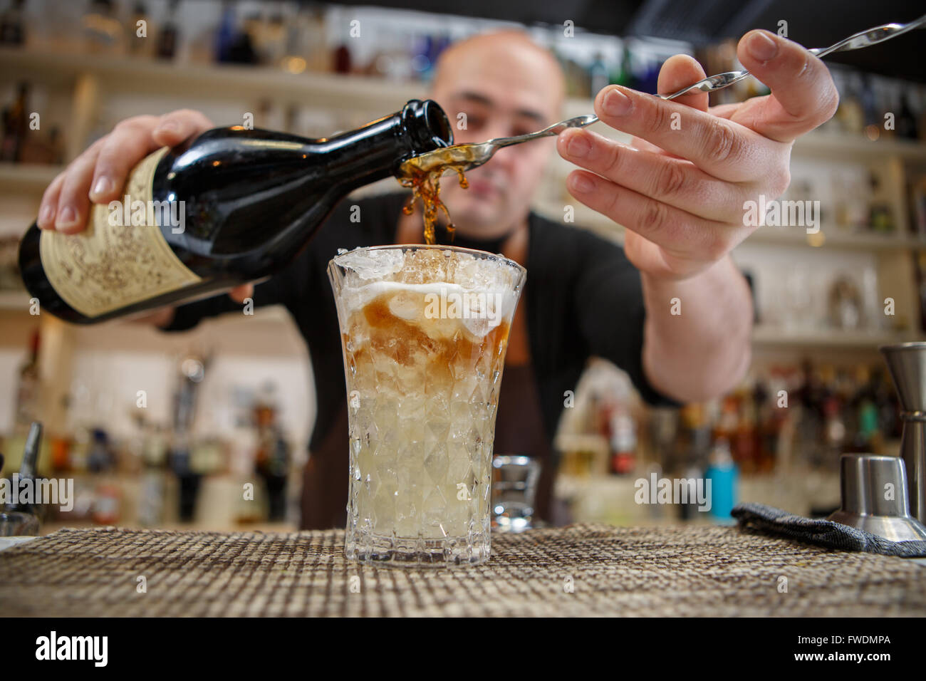 Bartender pouring cocktail into glass at the bar Stock Photo - Alamy
