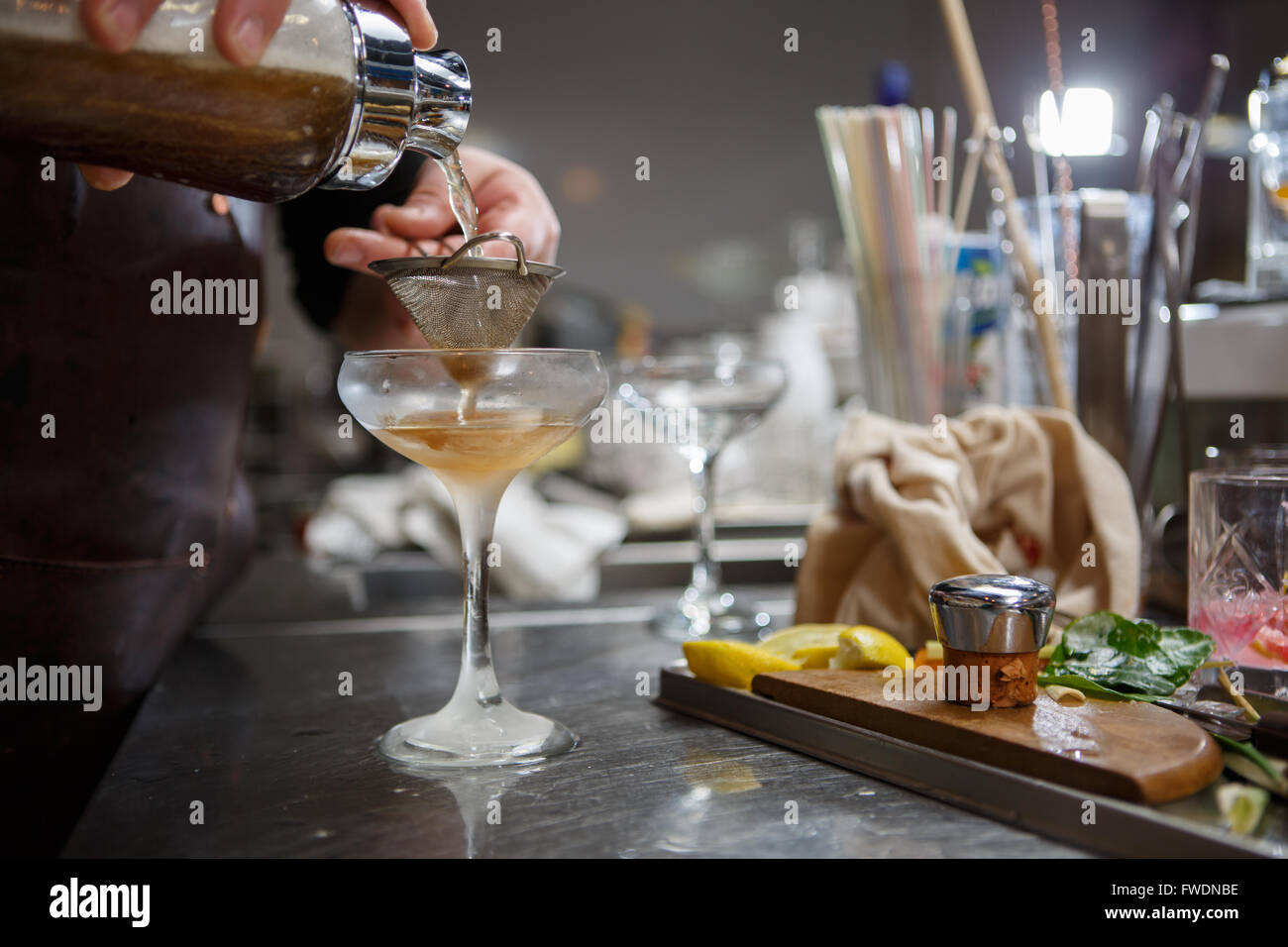 Bartender coocks cocktail behind a bar counter Stock Photo - Alamy